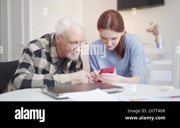An old man sits in a wheelchair and listens to a welfare woman. She ...