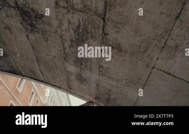 A tilt shot moving upward, capturing a skilled gondolier gracefully ...