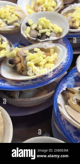 Close up of Fresh clams came out from shells to breath on black basket ...