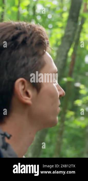 Black-haired young man enjoys hiking uniting with nature. Guy with blue ...