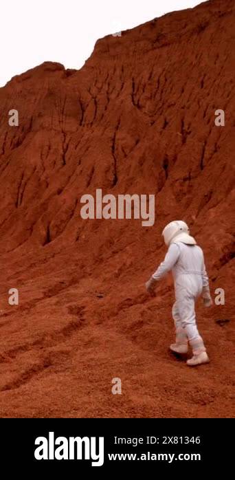 Astronaut exploring Mars surface tracking drone shot. Unrecognisable ...