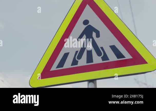 Bold pedestrian crossing sign against yellow and red background. Eye ...