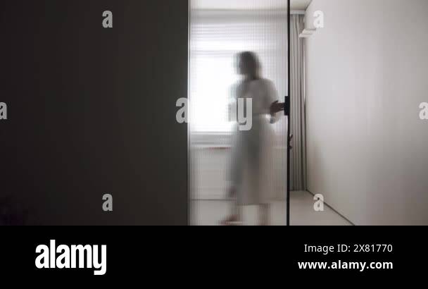Woman in robes open Transparent sliding door inside the modern bathroom ...