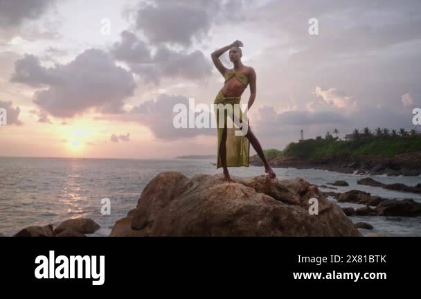 Godlike gender fluid person of color in open dress, jewelry stands at ...