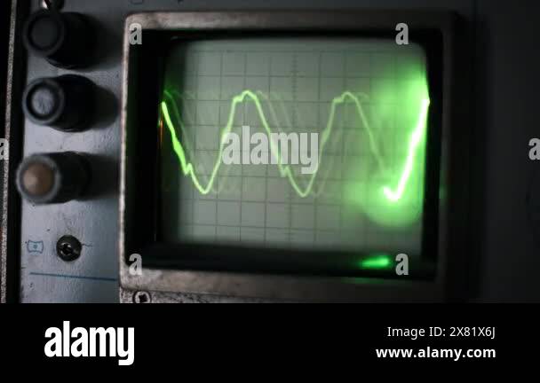 Vintage oscilloscope displays dynamic green signals on its screen ...