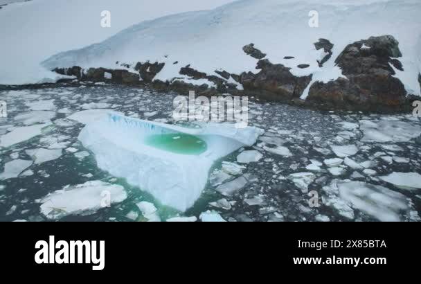 Zoom in large melting iceberg with green lake inside drifting in ...