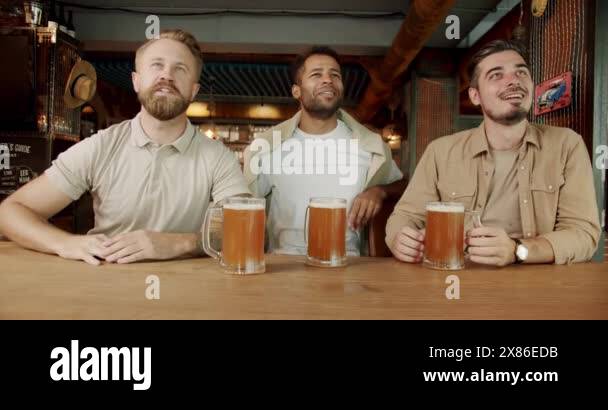 Fans watching football in a bar with friends. Soccer fans celebrating ...