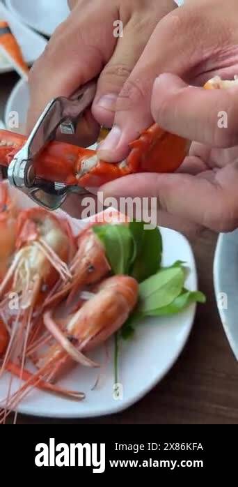 Hand of chef in restaurant during cut and removing shell of big size ...