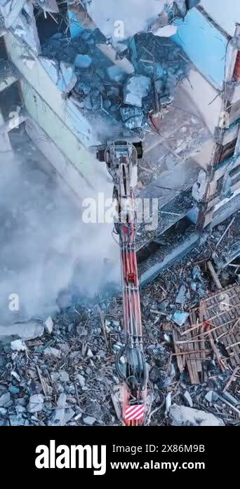 Demolishing machinery breaks the floors and walls of the ruin. Debris ...