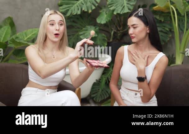 Two beautiful content creator making natural beauty and cosmetic tutorial on green plant leave ...