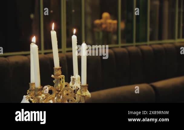 A candle holder on a wooden table is lit up with multiple candles ...