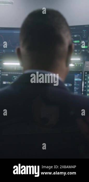 African American IT engineer works at computer with displayed real-time ...