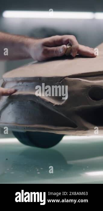 Two male automotive designers creating futuristic plasticine clay model ...