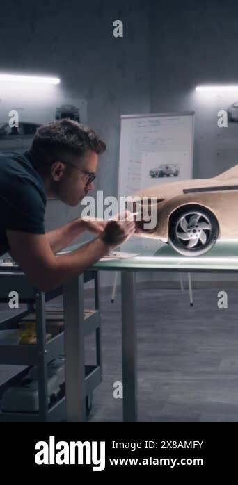 Two male automotive designers working on eco friendly plasticine clay ...