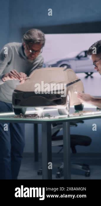 Two male automotive designers sculpting futuristic plasticine clay ...