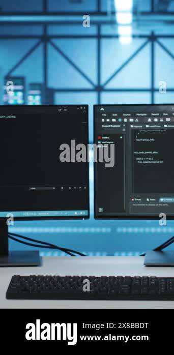 Vertical video Code running on computer screens in empty data center workspace, used for ...