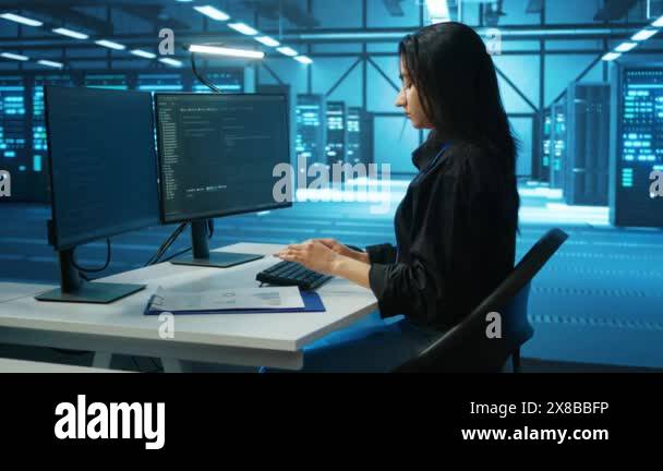 System administrator at PC desk working in computer network security data center, ensuring ...