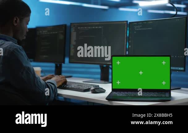 Isolated Screen Laptop Next To Programmer Coding In Server Farm Ensuring Valuable Data Remains