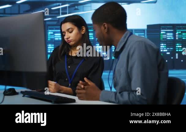 Coworkers in data center looking over annual systems review documents, discussing about ...