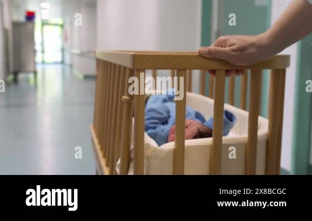 Newborn baby in a wooden crib being transported through hospital ...