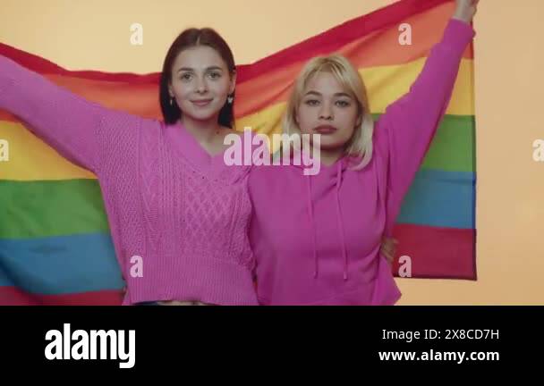 Couple Young Lesbians Girls Hugging Happily And Wrapped With Rainbow