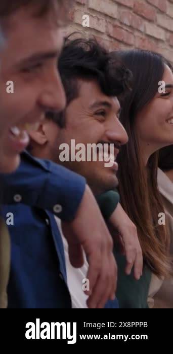 Vertical view group of international cheerful friends together hugging laughing. Happy ...