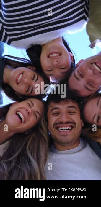 Vertical Multiracial group of young beautiful people standing in circle smiling excited camera ...