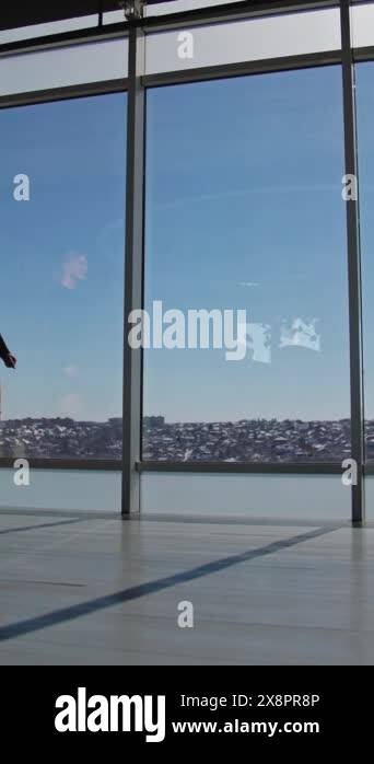 Female employees walk along the windows and talk. Ladies in black look ...