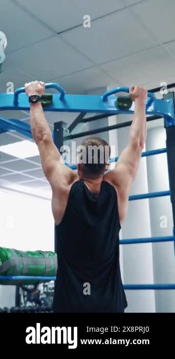 Back view portrait of a muscular man tightening in the gym. Guy ...