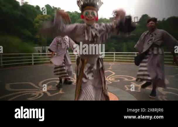 Traditional masked dancers in elaborate costumes performing an ethnic ...
