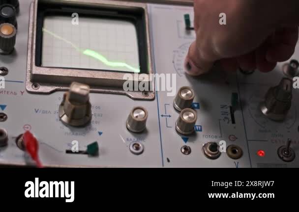 A vintage oscilloscope sits on a workbench, its screen displaying a ...