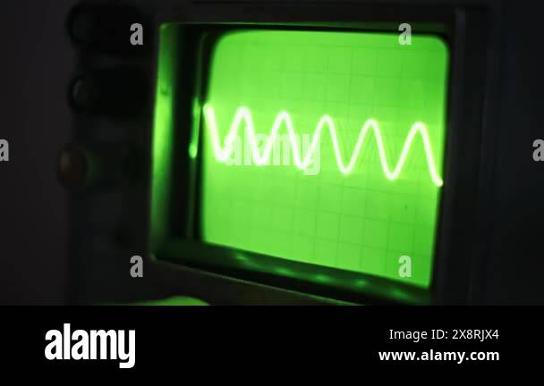 A vintage oscilloscope displays a stable waveform on its green CRT ...
