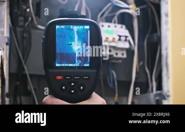 A technician uses a thermal imaging camera to inspect an electrical ...