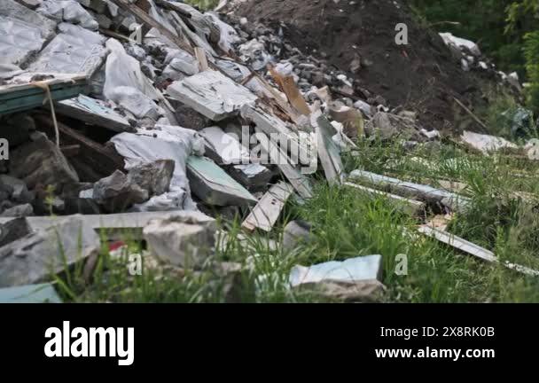 This clip shows a large pile of construction debris dumped in a forest ...