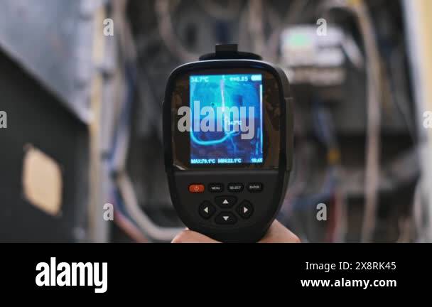 A thermal camera scans an electrical panel, revealing the heat ...