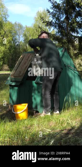 vertical video a man gets water from an old village well. Extraction of ...