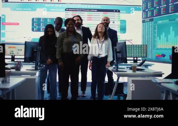 Diverse group of business professionals posing together in monitoring ...