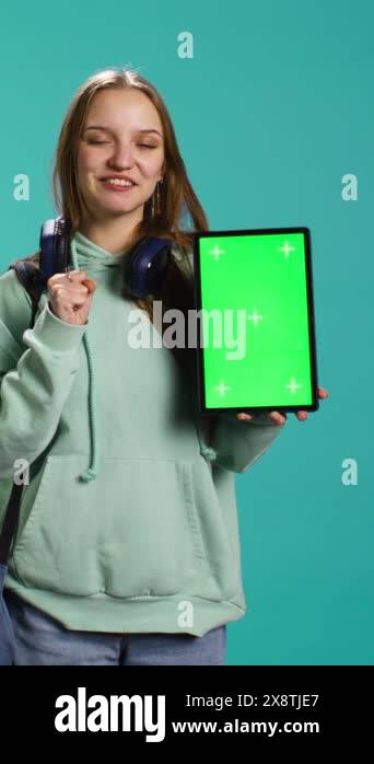Vertical video Portrait of woman presenting tablet with chroma key ...