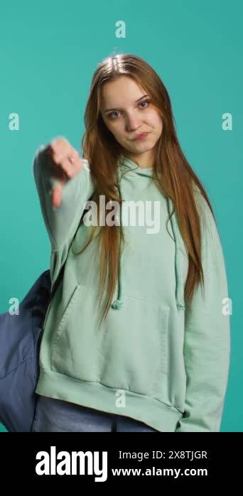 Vertical video Frustrated woman showing thumbs down sign gesturing ...