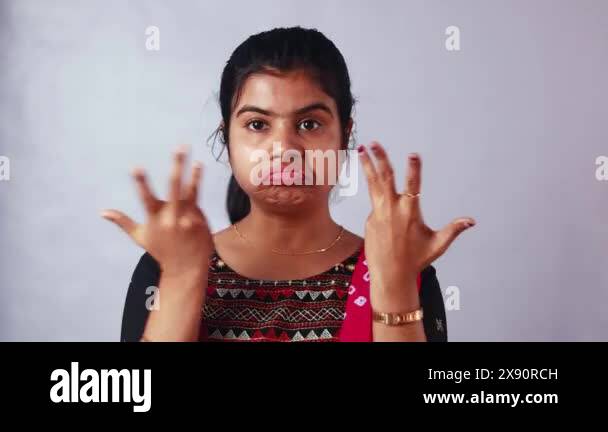 A pretty young Indian female making face of not understanding on white ...