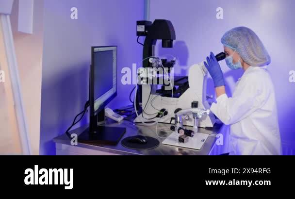 Embryologist performs artificial fertilization of human egg under a microscope in a laboratory ...