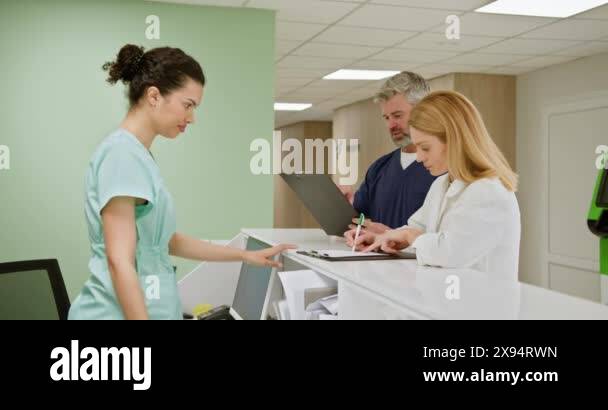 Group of medical staff at a hospital reception desk collaborating and ...