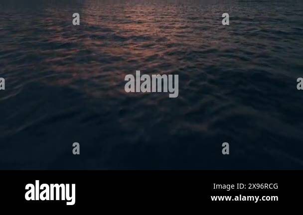 Quick flight over crystal clear water of ocean, revealing view of pink ...