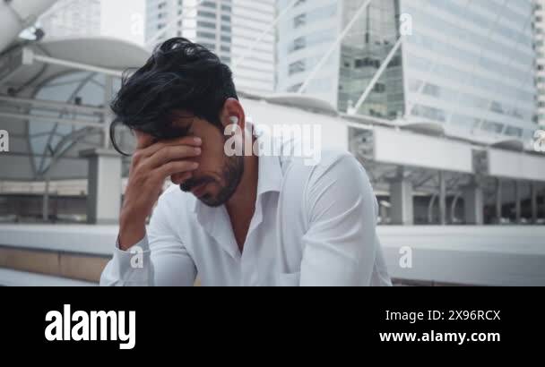 Middle Eastern man in wireless headphones sitting on steps street ...