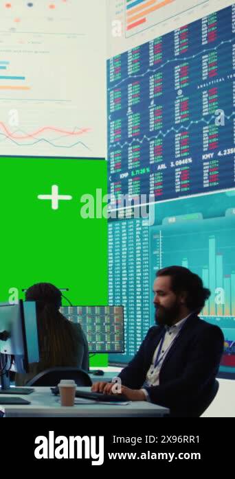 Vertical Video Business partners working in telecommunications control room with a big isolated ...