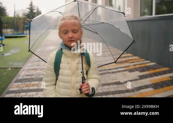Schoolgirl little girl going holding umbrella rain weather damp cloudy ...