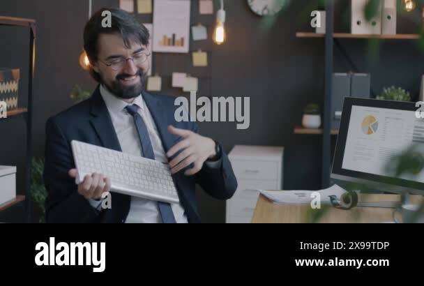Loop of happy Middle Eastern employee playing imaginary guitar with ...