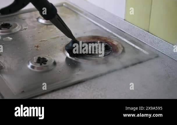 A handheld steam cleaner blasts away stubborn grease and grime from a ...