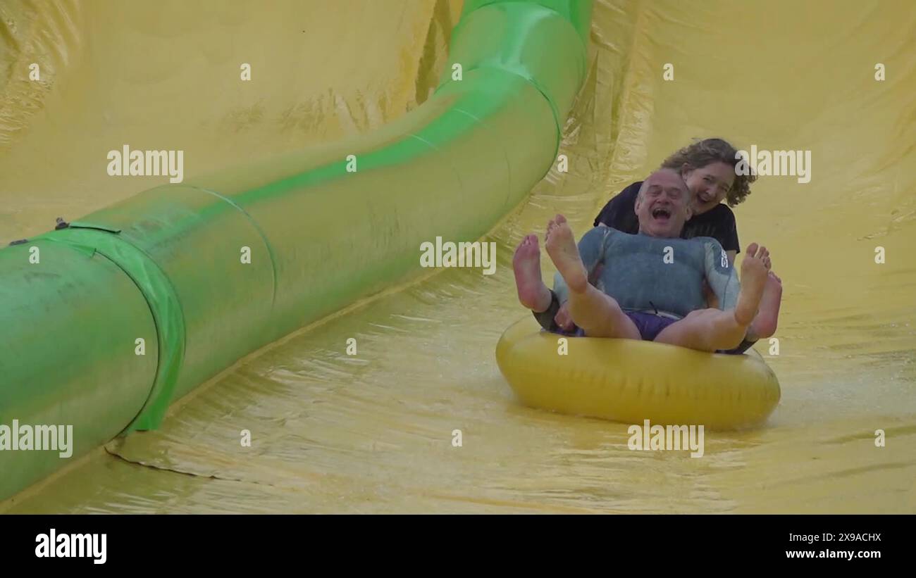 Ed Davey rides down waterslide in rubber ring Stock Video Footage - Alamy