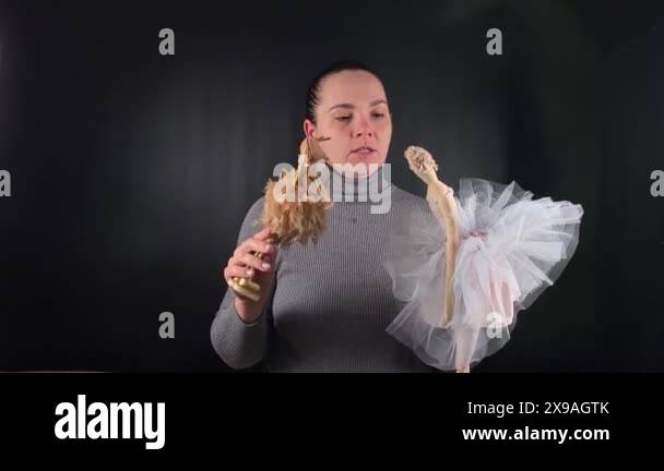 A portrait of a charming young white woman holding puppets, playing ...
